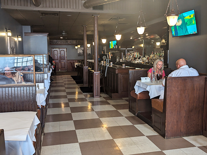 The checkered floor and wooden booths create that perfect balance of casual elegance where memories are made between bites.