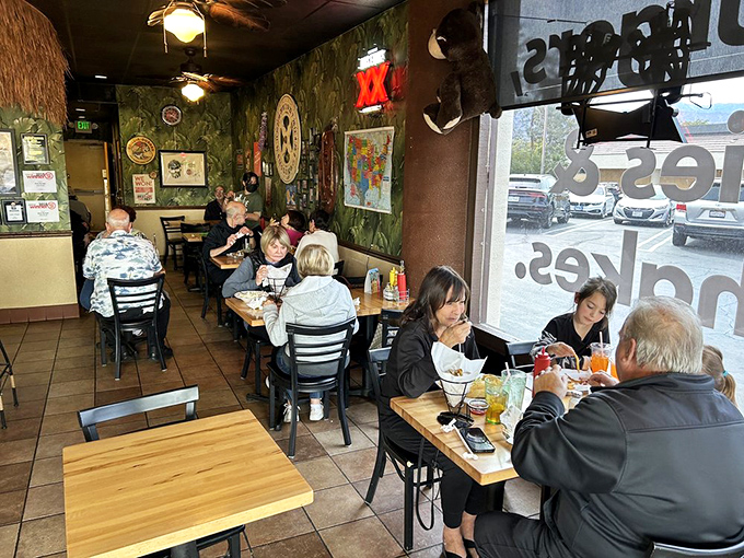 Families gather around wooden tables under jungle-themed walls where everyone finds something to love on the menu.