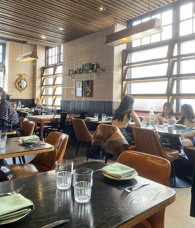 Sunlight streams through those distinctive windows, creating the perfect backdrop for a leisurely weekend brunch. The mint-green napkins add a subtle pop of color.