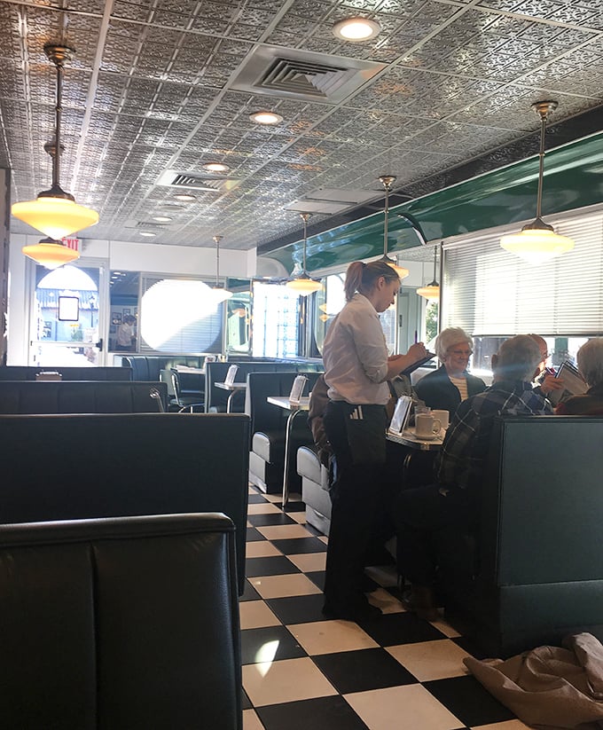 The diner's interior hums with conversation while servers navigate the checkerboard floor like chess pieces in a delicious game of breakfast strategy.