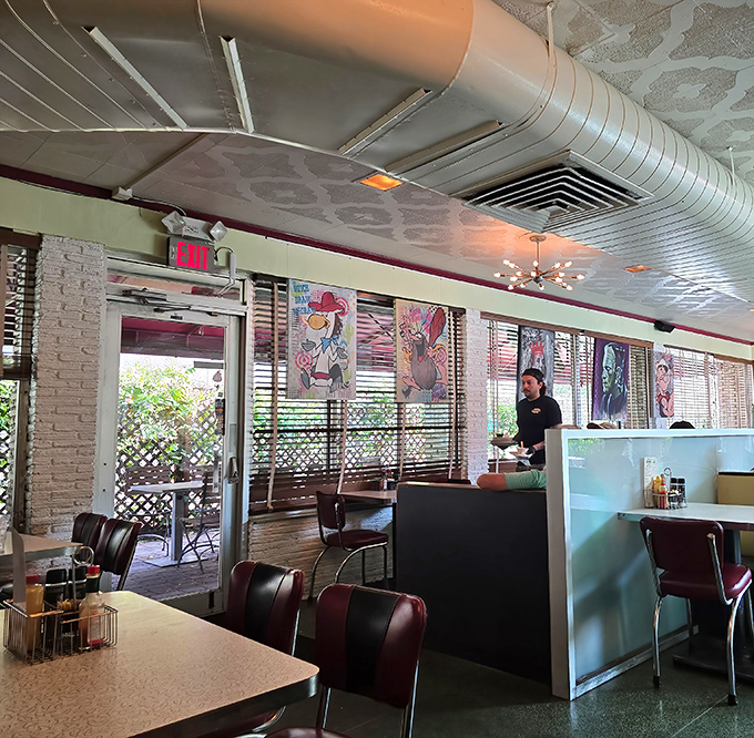 Classic diner aesthetics with pressed tin ceilings and art-adorned walls&mdash;where nostalgia meets comfort in perfect mid-century harmony.