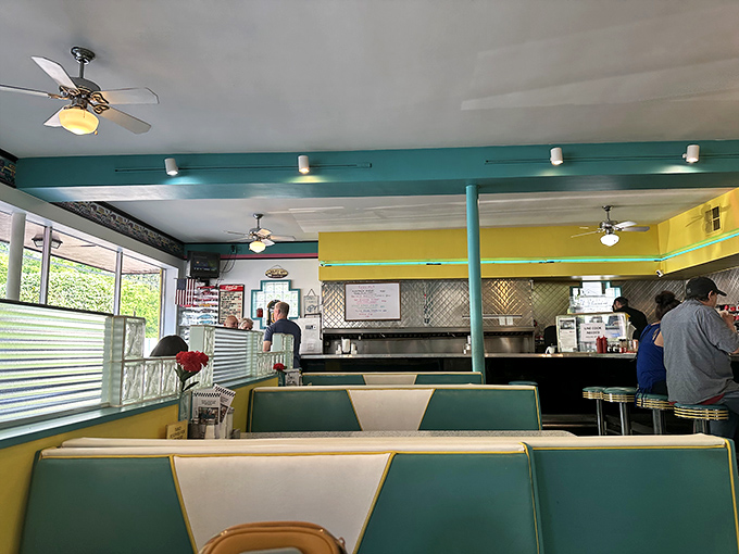 Classic booth seating in period-perfect turquoise and cream. The ceiling fans keep the atmosphere comfortable while conversations and coffee flow with equal enthusiasm.