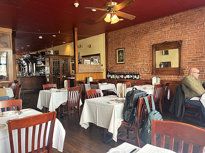 White tablecloths and wooden chairs create that perfect old-school steakhouse vibe where conversations flow as smoothly as the wine.