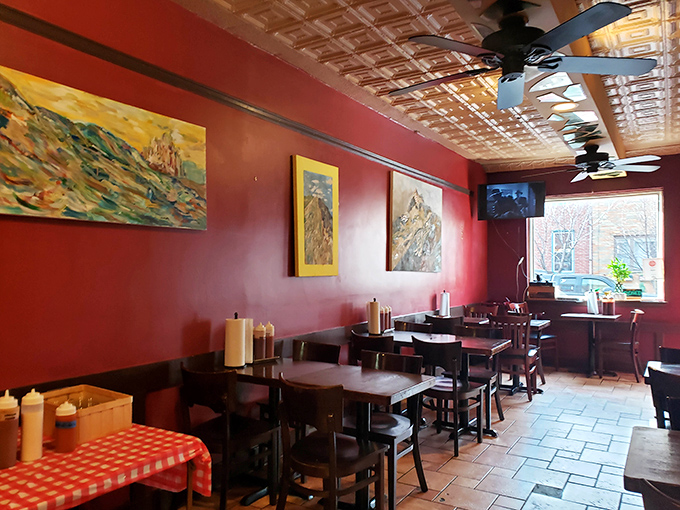 The dining room feels like the living room of that friend who always feeds you too well. Artwork on red walls adds character without distraction.
