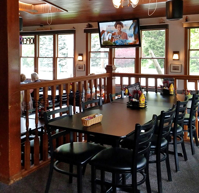 The dining area strikes that perfect balance between casual and cozy, with wooden railings and large windows letting in that magical Lake Erie light.