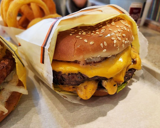 Cheese cascading down the sides of a double burger like a yellow waterfall of joy. This is burger architecture at its finest.