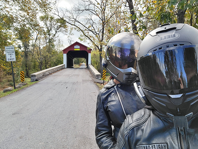 A motorcyclist pauses for a photo op, combining vintage transportation with vintage infrastructure&mdash;two classics appreciating each other.