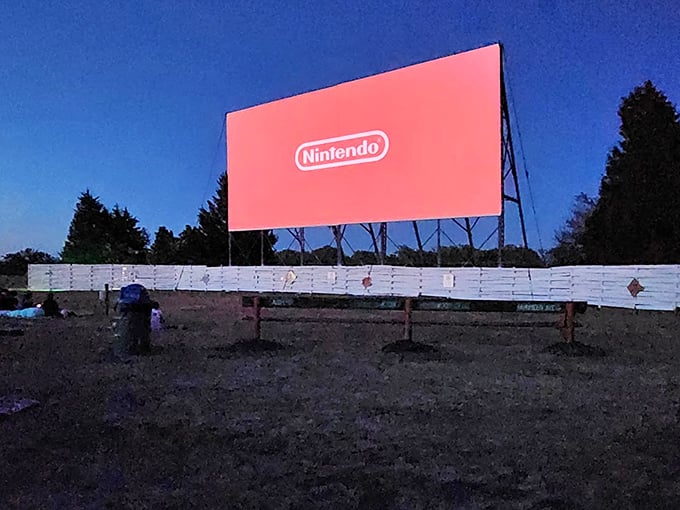 The Nintendo logo glows against the darkening sky, bridging generations as this vintage venue embraces modern entertainment while preserving its timeless charm.