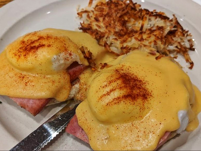 Eggs Benedict with hollandaise so golden it deserves its own Fort Knox, perched atop what appears to be Canadian bacon that actually came from Canada.