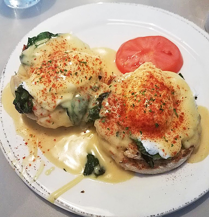 These eggs Benedict are having a moment, bathed in hollandaise and sprinkled with paprika like confetti at a breakfast parade.