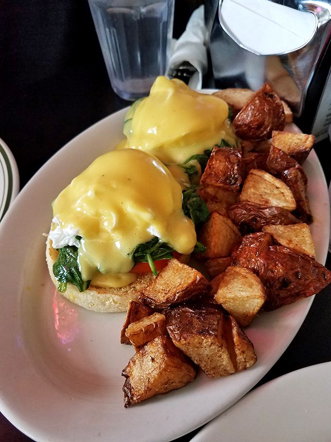 Eggs Benedict with a side of home fries that could make a potato farmer weep with pride. Hollandaise sauce: nature's perfect morning jacket.