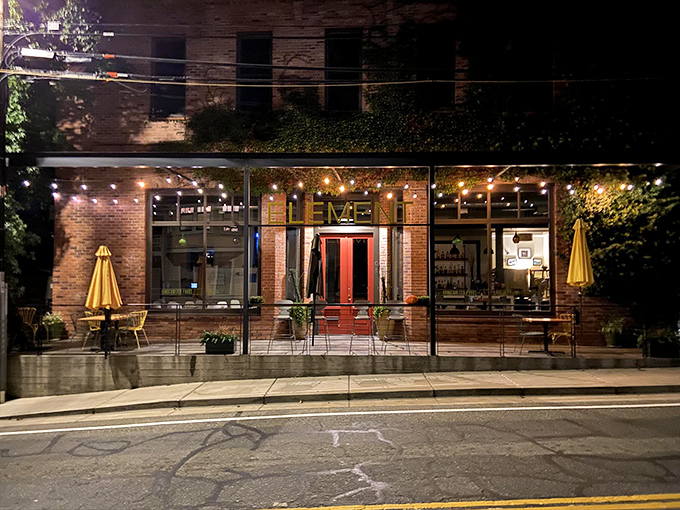 Element Restaurant glows with inviting warmth after sunset, its string lights and brick façade beckoning hungry travelers like a culinary lighthouse.