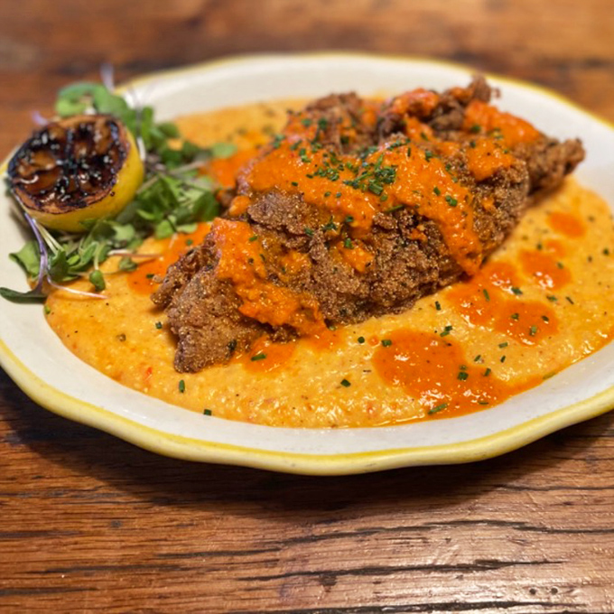 Southern meets seafood in this fish and grits masterpiece, where crispy catfish lounges on creamy grits like it's taking a delicious spa day.