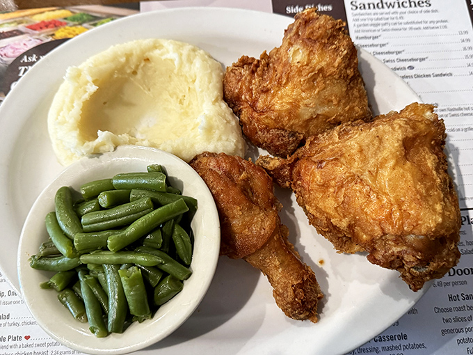 Fried chicken so perfectly golden it practically glows, paired with green beans and mashed potatoes that aren't just sides—they're supporting stars.