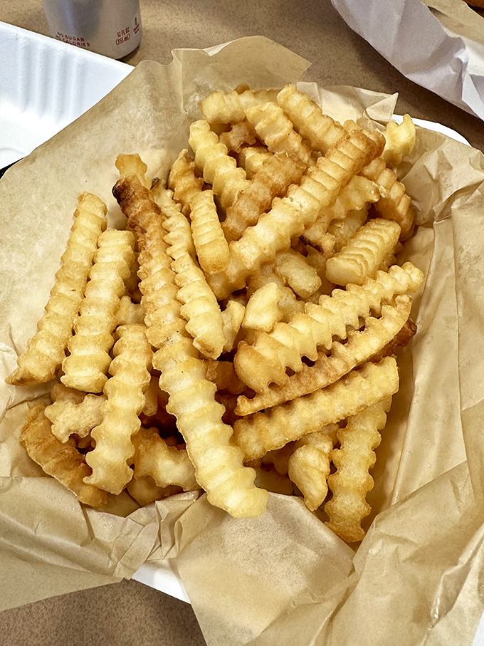 Crinkle-cut fries that achieve the impossible: crispy exterior, fluffy interior, and the power to disappear before you realize you've eaten them all.