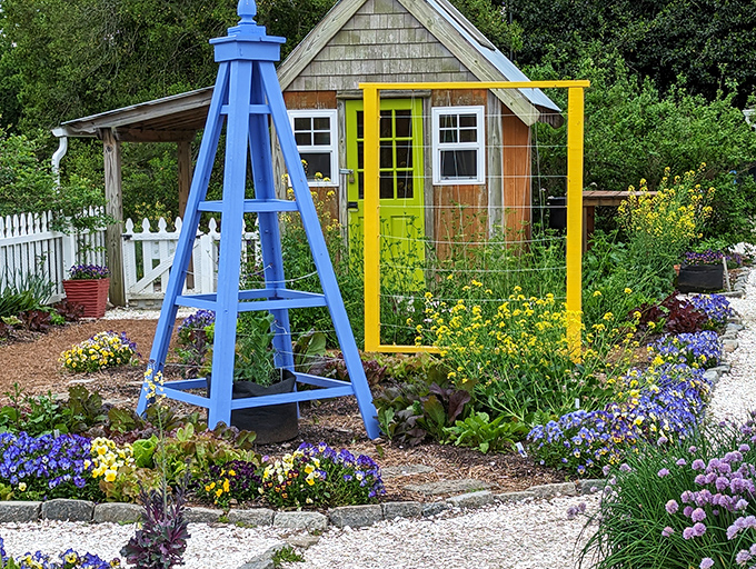 Cottage garden charm with a playful twist. That blue lighthouse and yellow frame aren't just decorative&mdash;they're conversation starters with flowers.