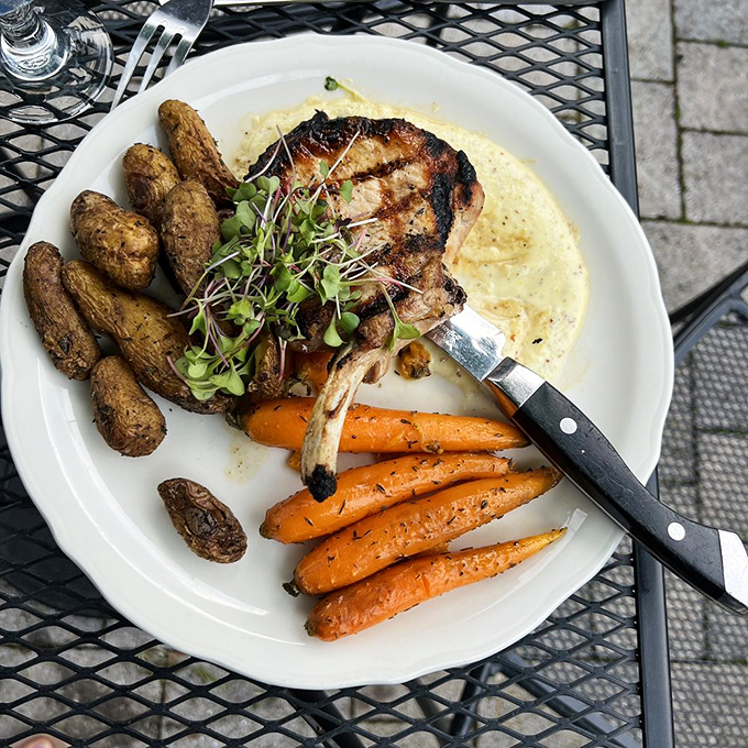 This isn't just a pork chop&mdash;it's a statement. Perfectly seared and resting on a cloud of sauce with vegetables that actually deserve to be on the same plate.