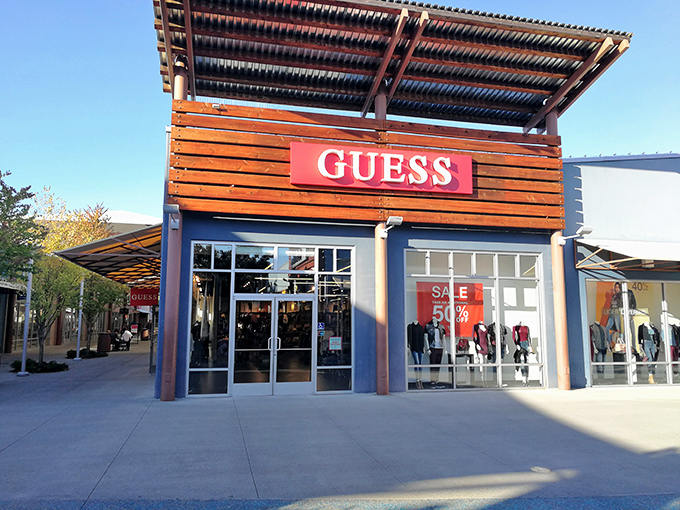 The GUESS storefront with its bold 50% off signage represents the siren call that lures bargain hunters from miles around.