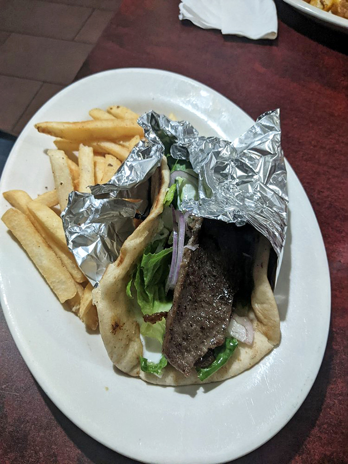 A proper gyro wrapped in foil like the gift it is, with a side of fries that didn't come from a freezer bag. Simple pleasures done right.