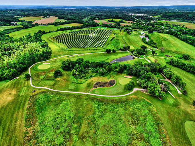 This aerial view of Hales Mills Country Club showcases rolling greens where your golf game might not improve, but your blood pressure certainly will.