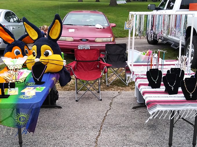 A rainbow of handcrafted jewelry flanked by whimsical mascots. One table, two completely different collecting obsessions.
