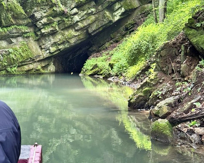 Where daylight meets darkness: the cave's watery entrance beckons adventurers into a world where time is measured in millennia, not minutes.