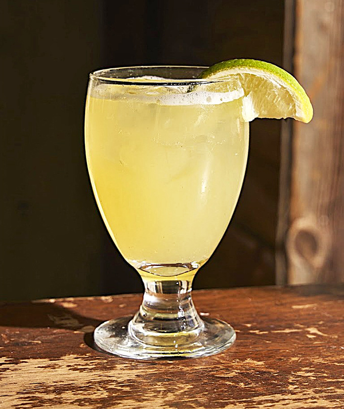 A margarita with a lime wedge perched hopefully on the rim, ready to cut through the richness like a citrus superhero.