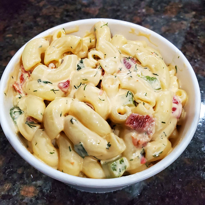 Not your cafeteria mac salad. Creamy, tangy, with bits of fresh vegetables adding crunch and color to this perfect chicken companion.