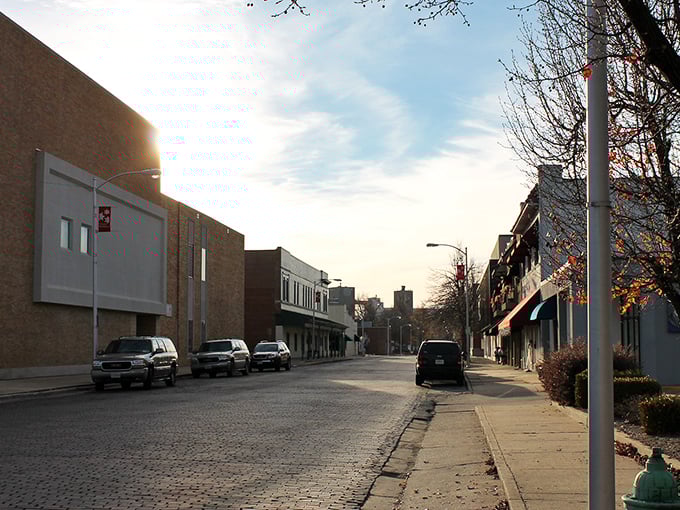 Winter light bathes downtown's brick streets in golden hour warmth, transforming ordinary storefronts into a scene worthy of a Rockwell painting.