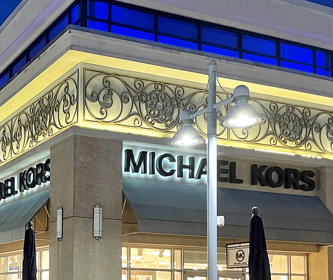 Michael Kors at night &ndash; where handbags gleam under strategic lighting, making your credit card practically leap from your wallet.