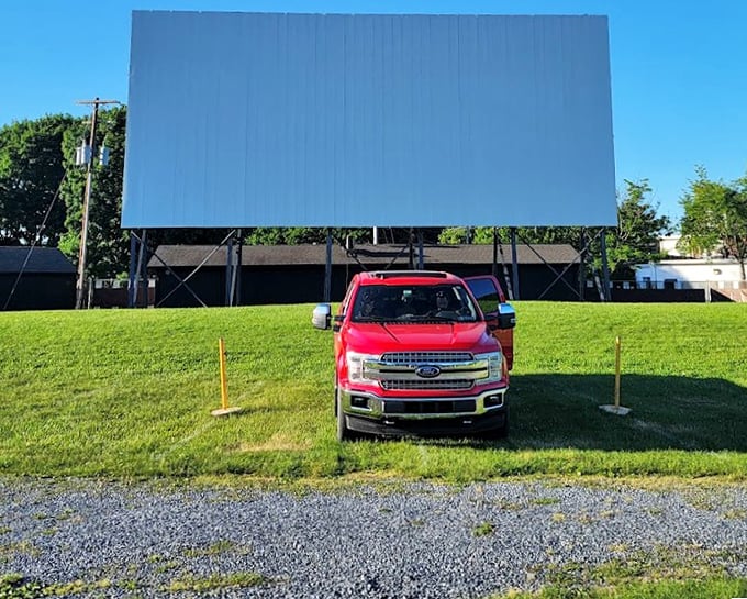 A shiny red Ford truck claims prime real estate in front of that glorious white screen.