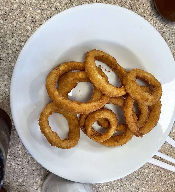 Golden onion rings with that perfect crunch-to-softness ratio – the supporting actor that often steals the whole diner show.