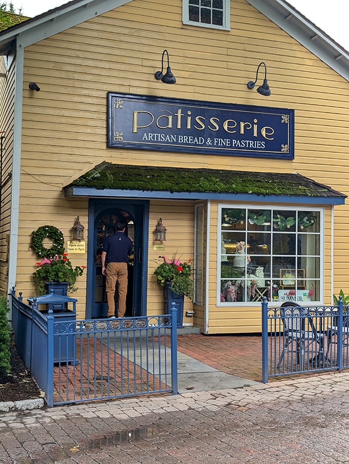 The sunny yellow Patisserie building practically shouts "happiness inside!" with its cheerful fa&ccedil;ade and wreath-adorned blue door.