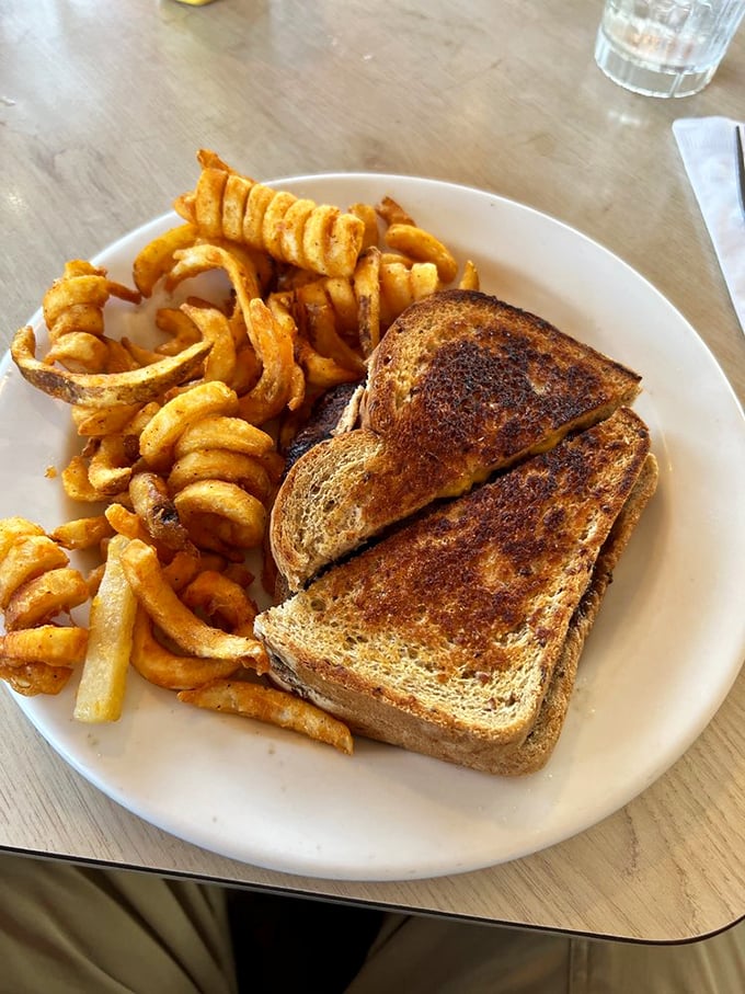 A grilled sandwich and curly fries that would make any road trip worth it. Simple perfection that doesn't need Instagram filters to impress.