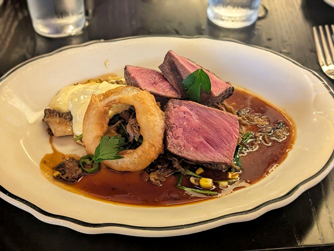 Perfectly pink peppercorn steak swimming in savory jus&mdash;the kind of plate that silences conversation for all the right reasons.