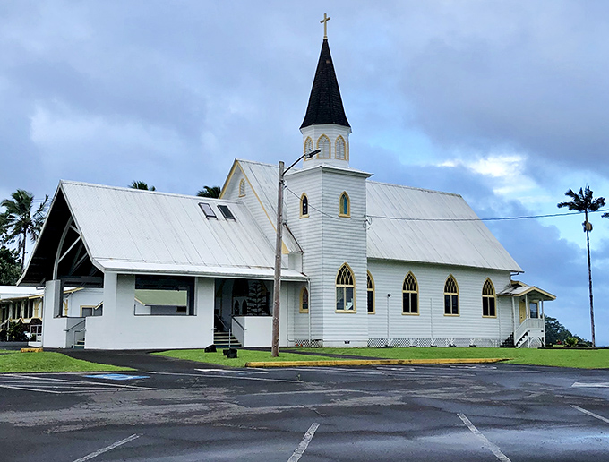 Sacred Heart Church stands serene against the Hawaiian sky, its white clapboard a beacon of calm in a land of geological drama.