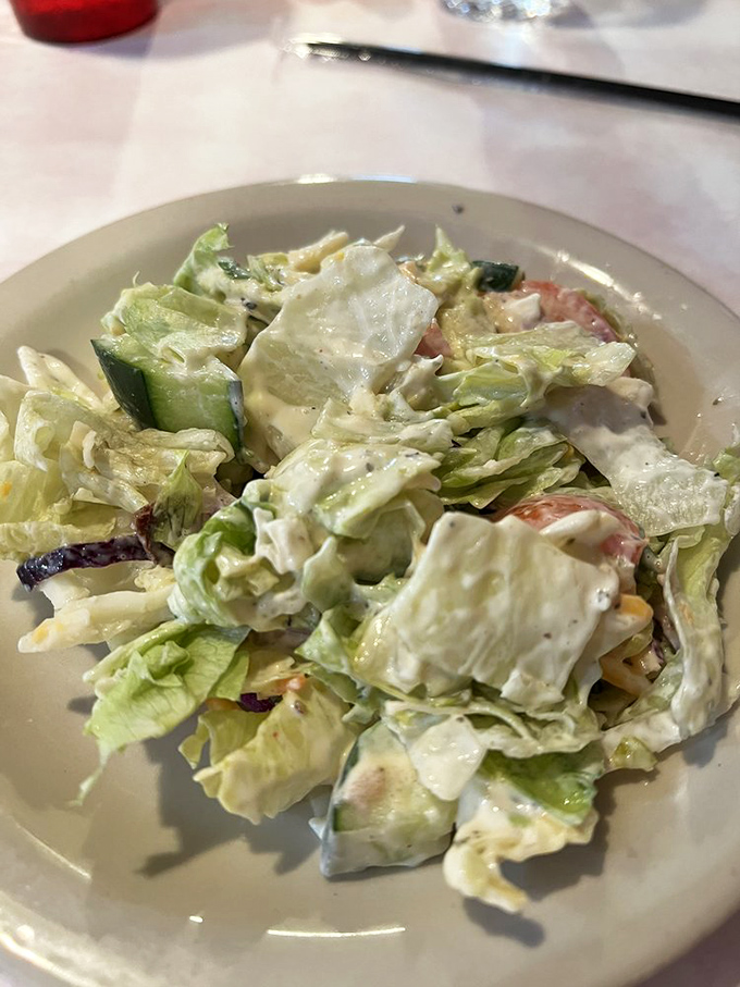 A house salad that defies the "obligatory vegetable" category—fresh, crisp, and generous enough to feel like more than just a prelude.