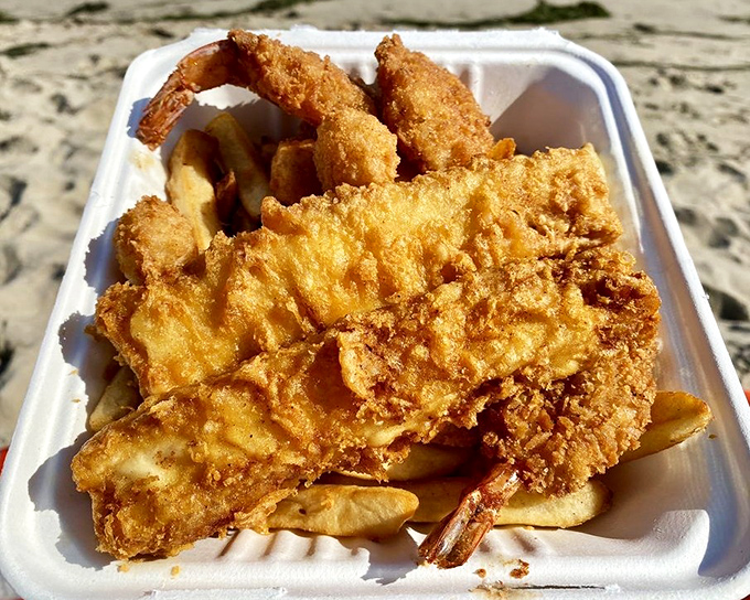 Golden-battered fish and shrimp nestled among fries—proof that sometimes the most satisfying meals come in humble paper containers.