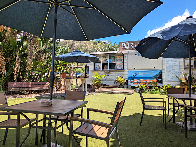 Outdoor dining perfected: umbrella-shaded tables, tropical plants, and a food truck serving up meals worth writing home about.