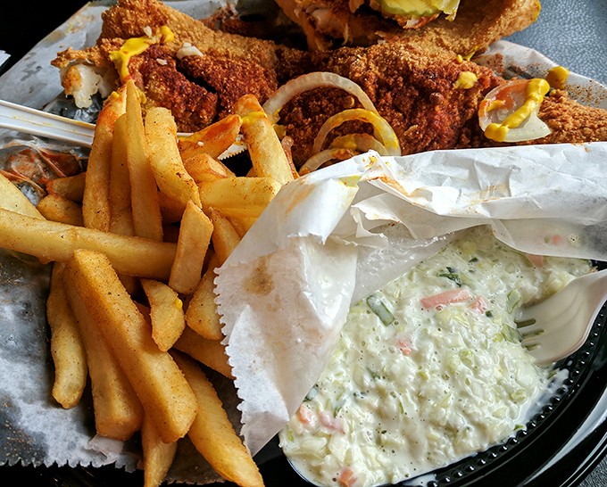 The perfect supporting cast: golden fries and creamy slaw. One amplifies the heat experience, the other offers merciful relief between bites.