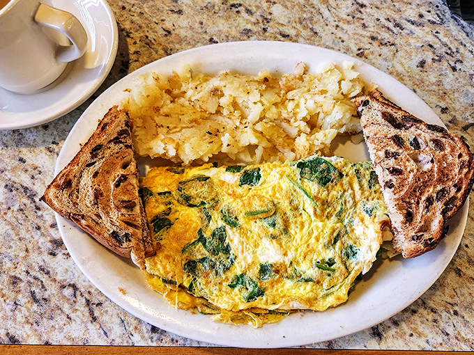 A spinach omelet that Popeye would approve of, flanked by perfectly toasted rye and hash browns that strike the ideal crispy-to-fluffy ratio.