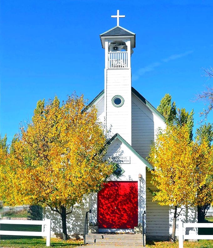 St. Barnabas' Episcopal Church stands like a postcard come to life, framed by autumn gold and Wyoming's signature blue sky.