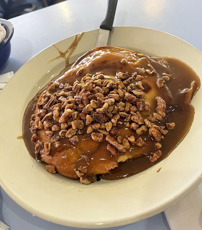 A sticky bun that doesn't apologize for its decadence, swimming in caramel and topped with enough pecans to make a squirrel weep with joy.