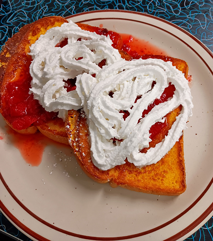 French toast that looks like it's dressed for prom night, with strawberry topping and whipped cream performing their sweet duet of breakfast decadence. 