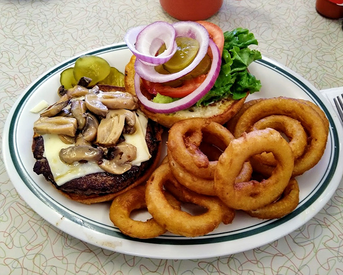 A burger that understands the assignment. Those onion rings aren't just sides&mdash;they're golden halos of deep-fried perfection.