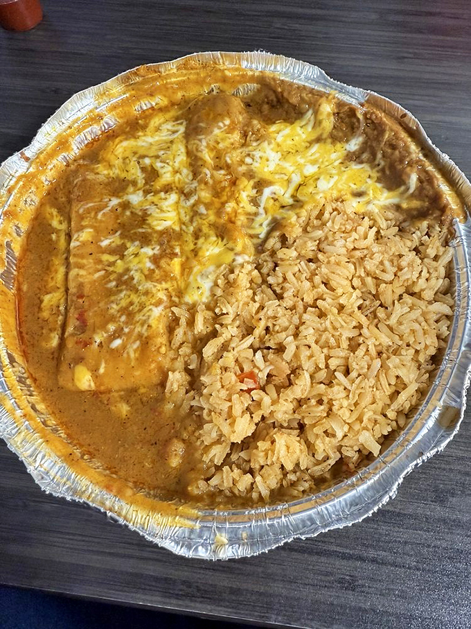 A tamale that's been steamed to perfection, then smothered in red sauce that could make a grown adult weep. The rice is there to soak up your tears of joy.