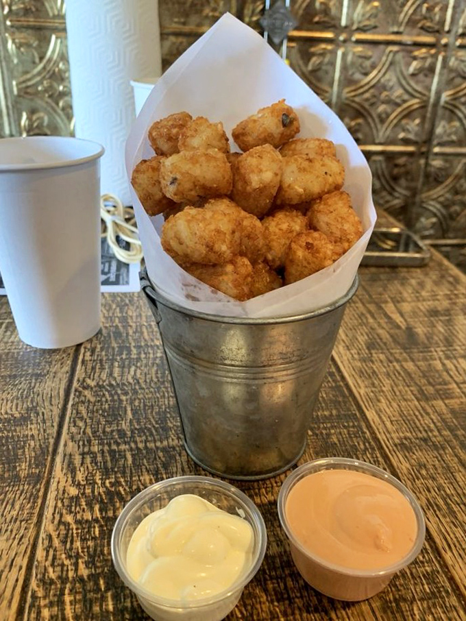 Golden-brown tater tots standing at attention in their metal bucket &ndash; the crispy soldiers of satisfaction that no burger should go to battle without.