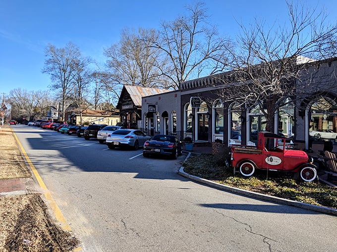 These storefronts with their vintage charm house businesses where shopkeepers still remember your name—and that classic red truck is just showing off for the tourists.