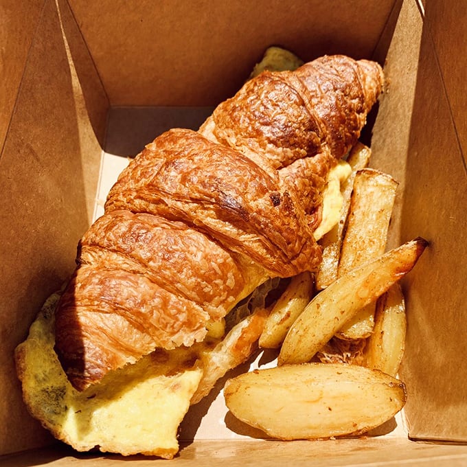 A croissant sandwich with golden fries that makes you question why you ever settled for drive-thru breakfast. This is what morning victory looks like.