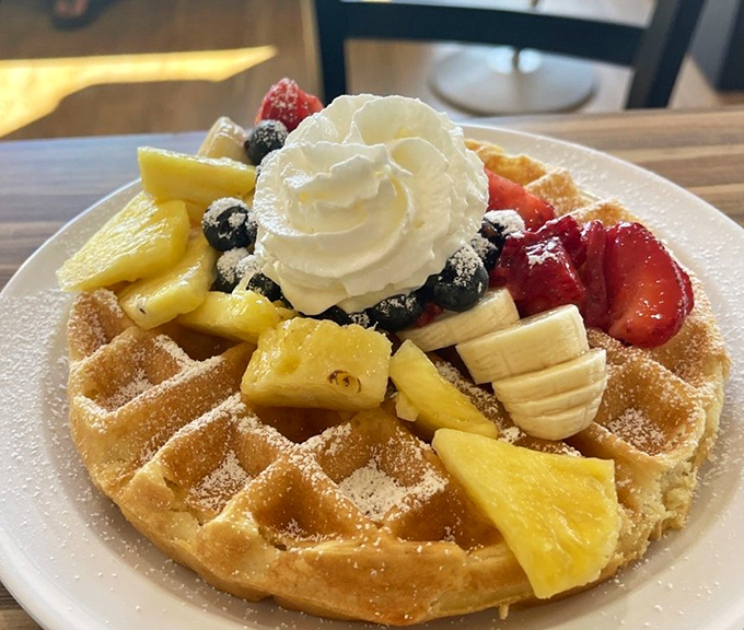 This waffle wears its fruit like crown jewels, with whipped cream as the cloud on which breakfast dreams are built.